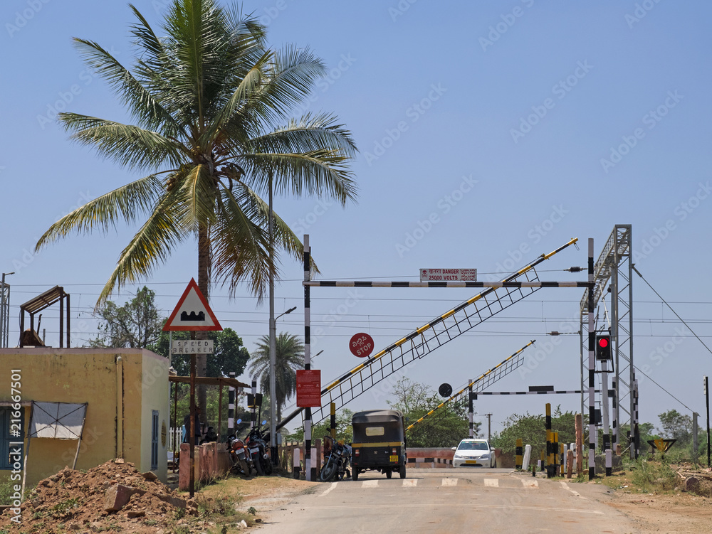 Barriers descending at a railroad crossing in Karnataka. Safety on the ...