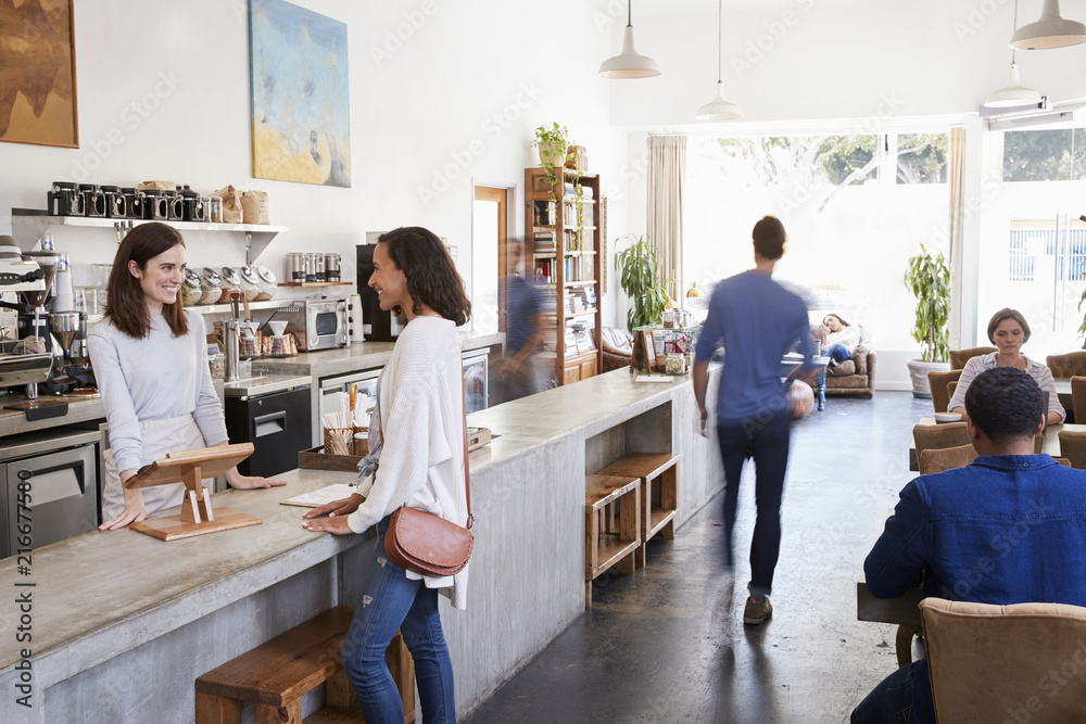 Female customer ordering at the counter in a coffee shop Stock Photo ...
