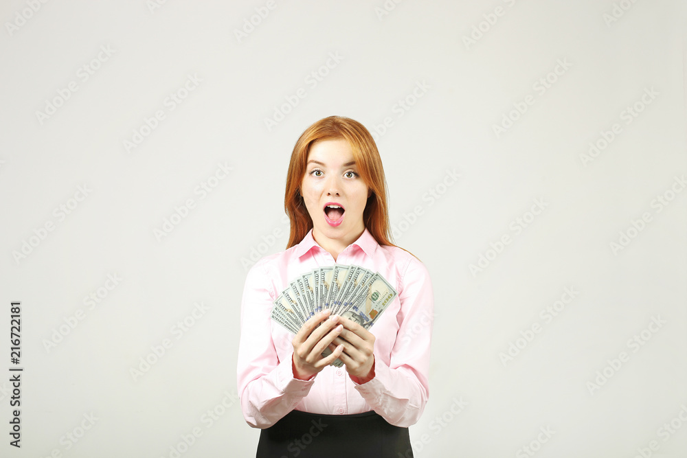 Young beautiful redhead woman covering her face with fistful of money ...