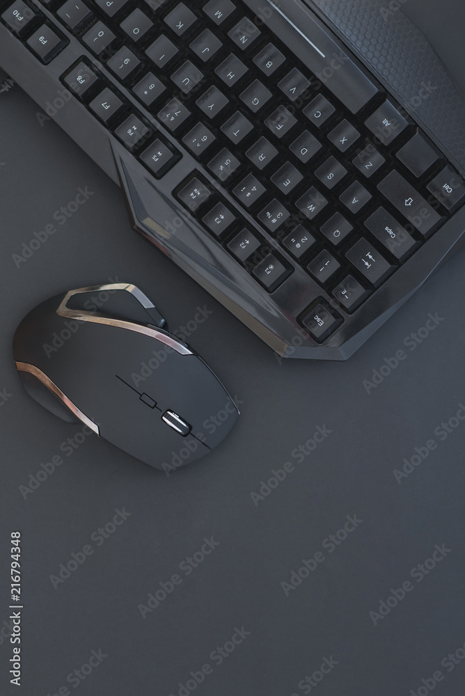 Black mouse, keyboard isolated on a dark background, top view. Flat lay ...