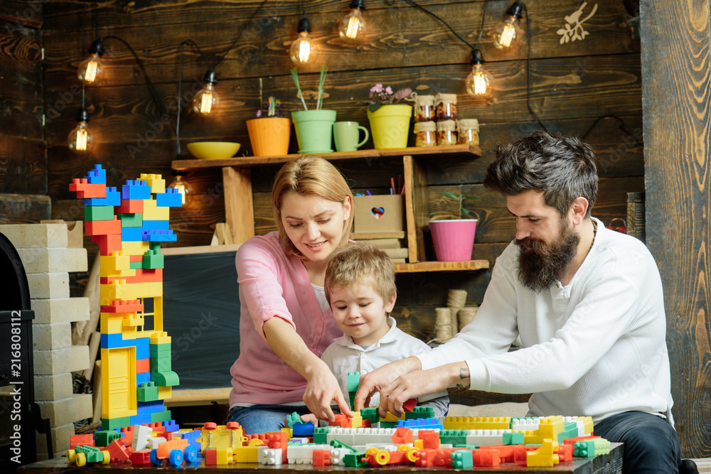 Construction concept. Little child with mother and father play with toy ...