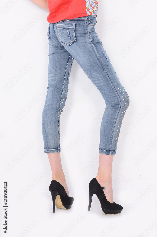Side view women legs in jeans with black high hell shoes posing in studio Stock Photo | Adobe Stock
