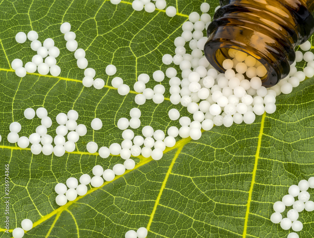 Globuli on green leaf and apothecary bottle Stock-Foto | Adobe Stock