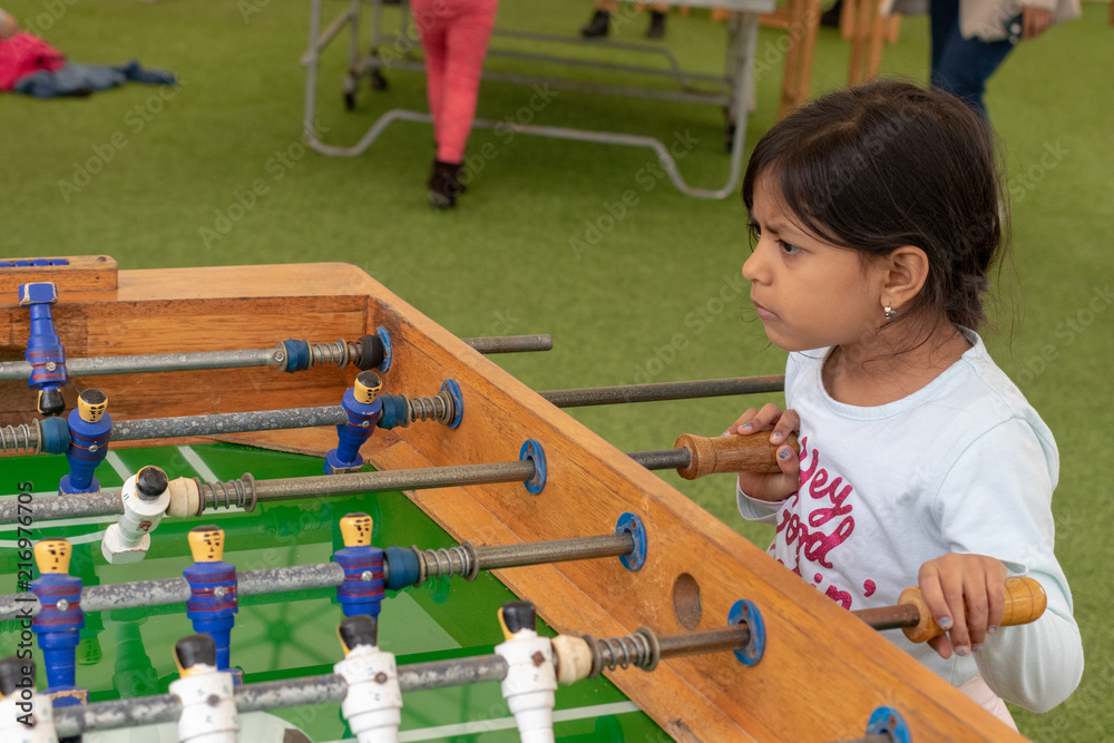 Cute little girl playing table football Stock Photo | Adobe Stock