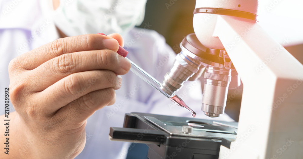 Hands of young Asian man and white microscope in science laboratory ...