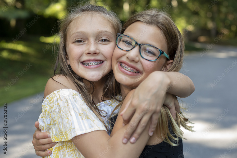 Tween Girls in Middle School Hugging Stock Photo | Adobe Stock