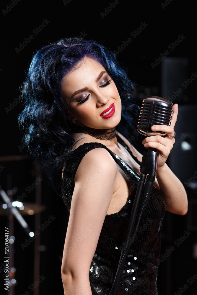 Beautiful singing glamour woman with retro microphone on the stage ...