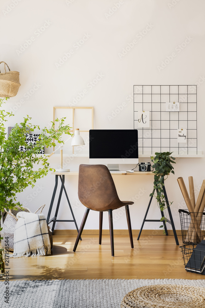Modern computer screen on an industrial desk by a white wall in a warm ...