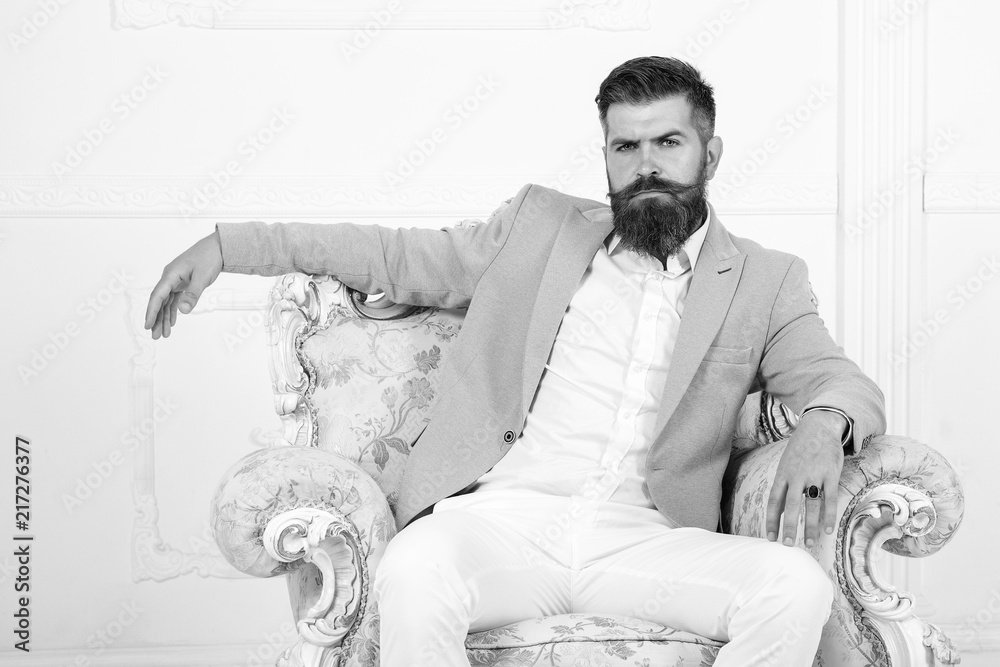 Cool man in formal wear, sit in chair over white background, shares ...