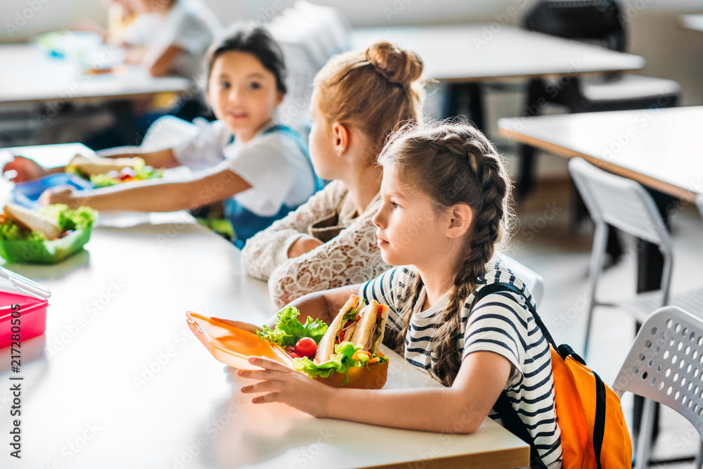group of schoolgirls taking lunch at school cafeteria together Stock ...
