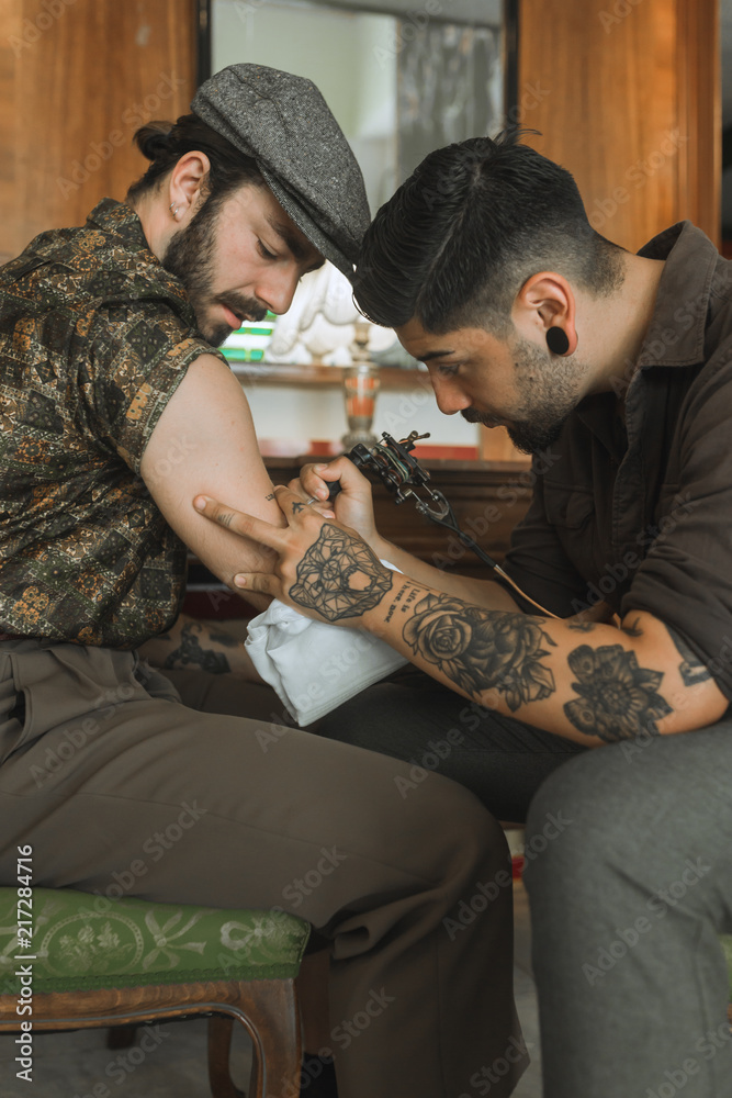 Vintage men tattooing and posing in a retro bar Stock Photo | Adobe Stock