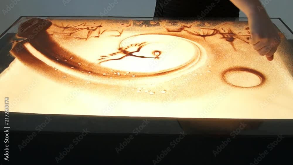Drawing with sand. Drawing sand on a white screen. Sand Artist. Hands ...