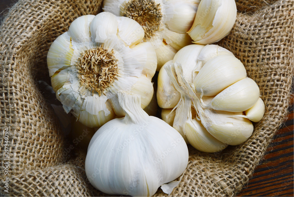Close up Many Garlic in sack bag on wooden background. Stock Photo ...