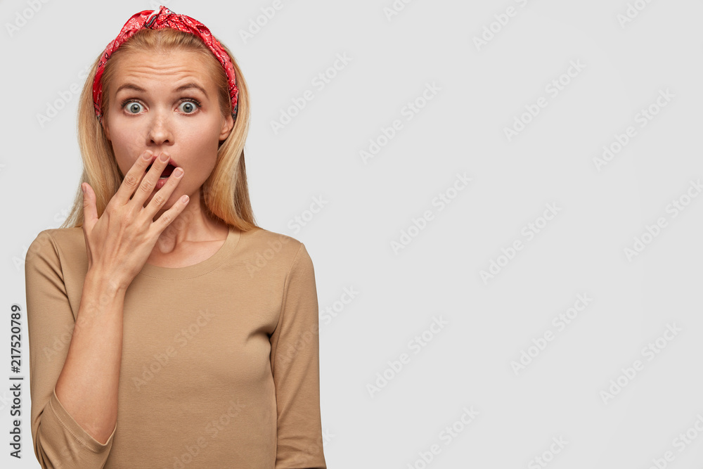 Astonished blonde female with surprised expression, stares with bugged ...