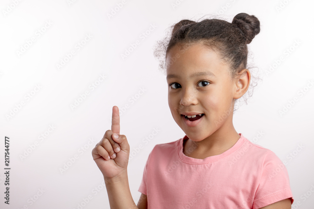 clever girl raising her finger up.posotive kid is pointing at the copy ...