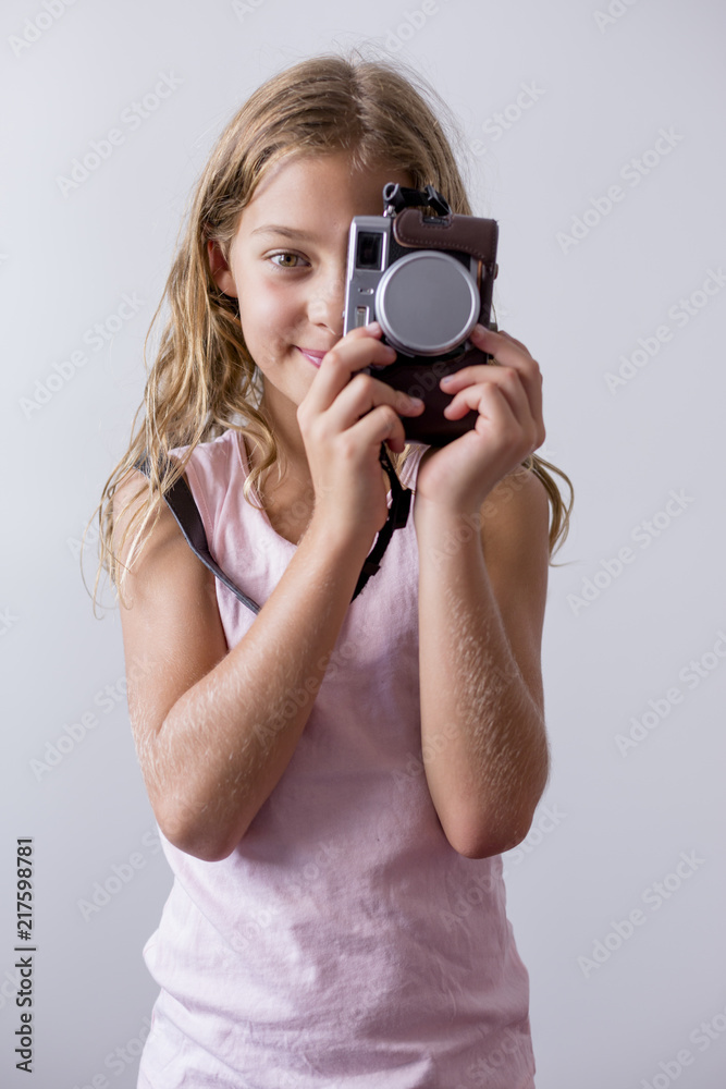 portrait of a young beautiful kid holding a vintage camera and smiling ...