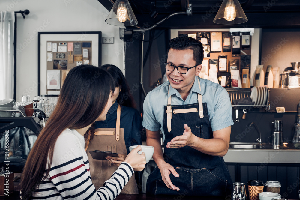 Male barista talking with customer about tasted of coffee cup with ...
