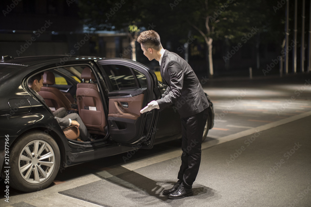 Chauffeur opening car door for passenger Stock Photo | Adobe Stock