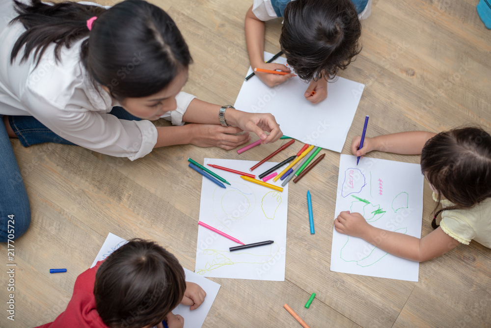 Group of preschool student and teacher drawing on paper in art class ...