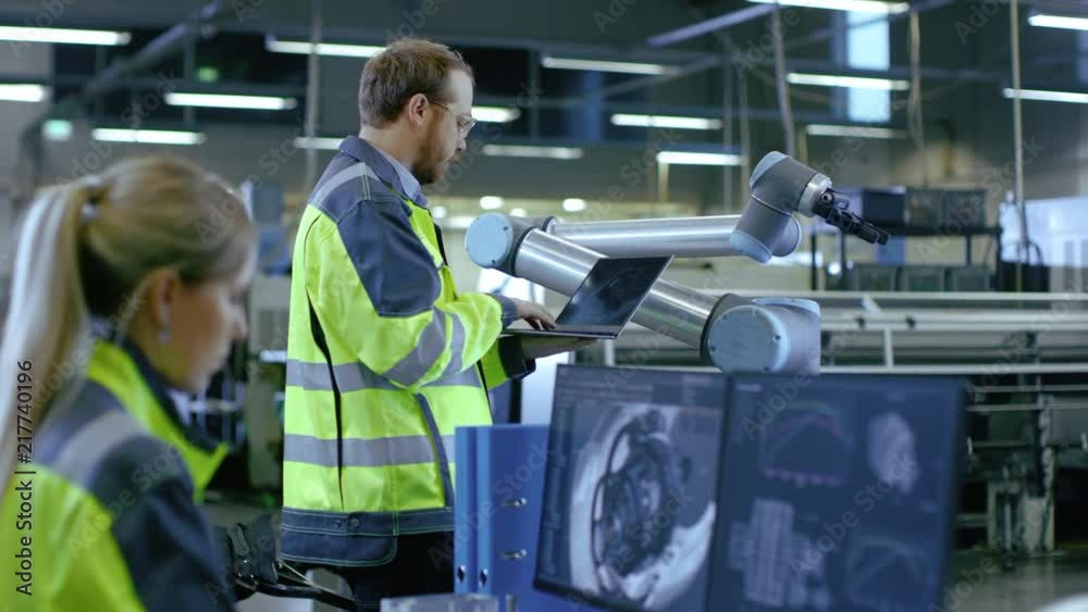 At the Factory: Male Automation Engineer Uses Laptop for Programming ... At the Factory: Male Automation Engineer Uses Laptop for Programming ...