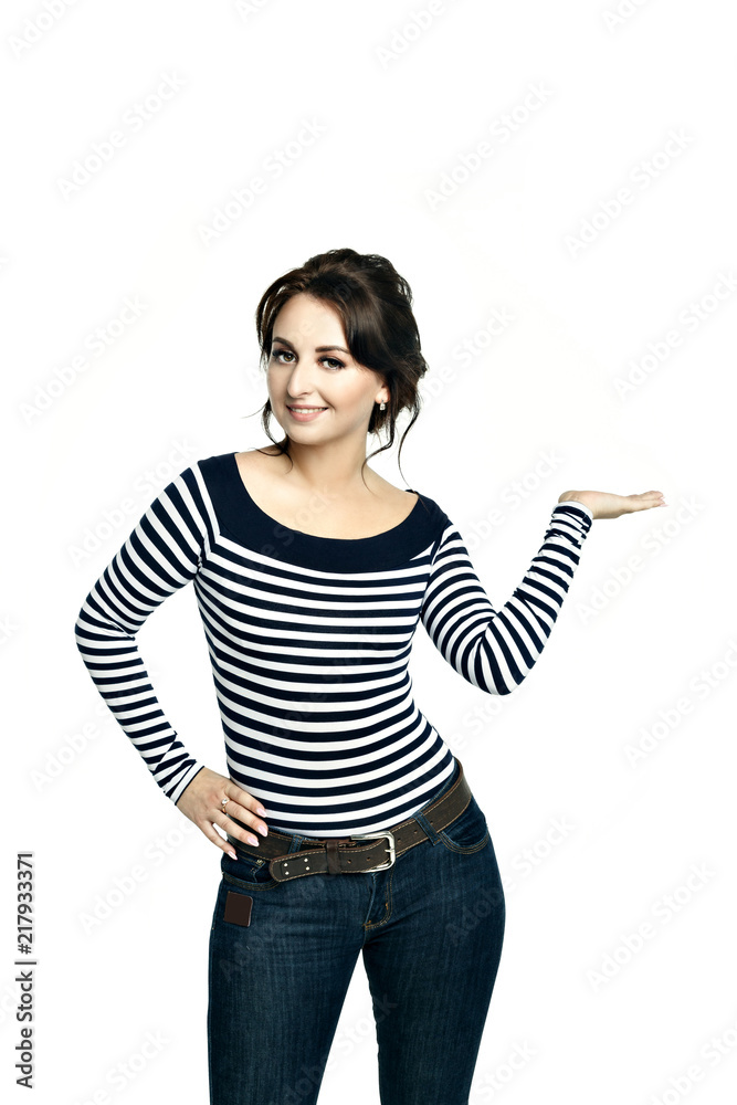 A young woman in a striped tight blouse and blue jeans, one hand on the ...