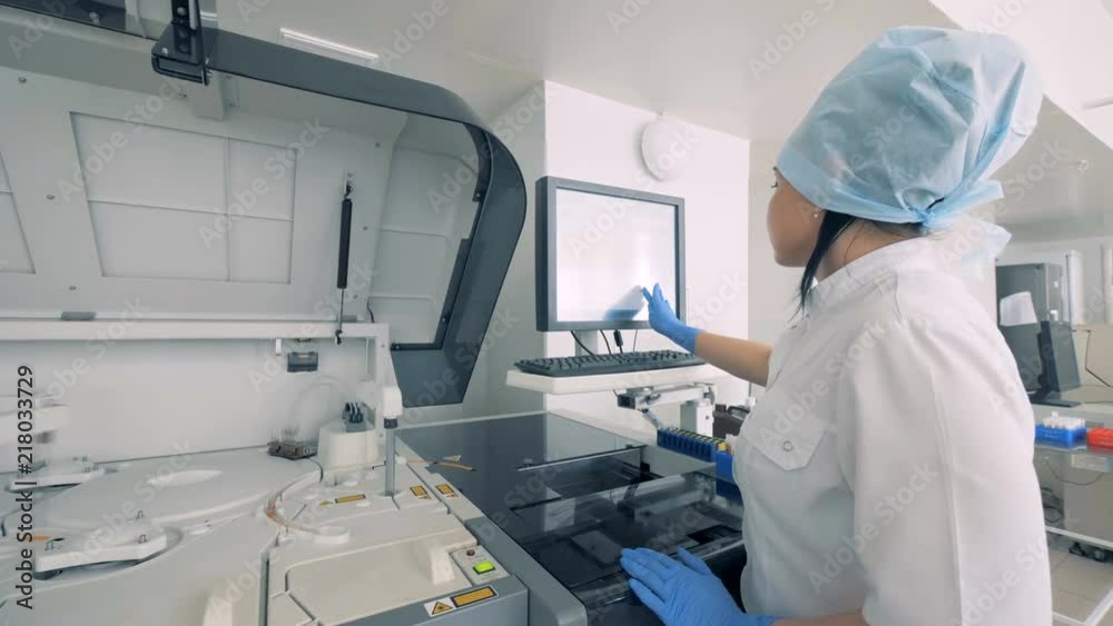 Biochemical analyzing machine is being managed by a lab worker at a ...