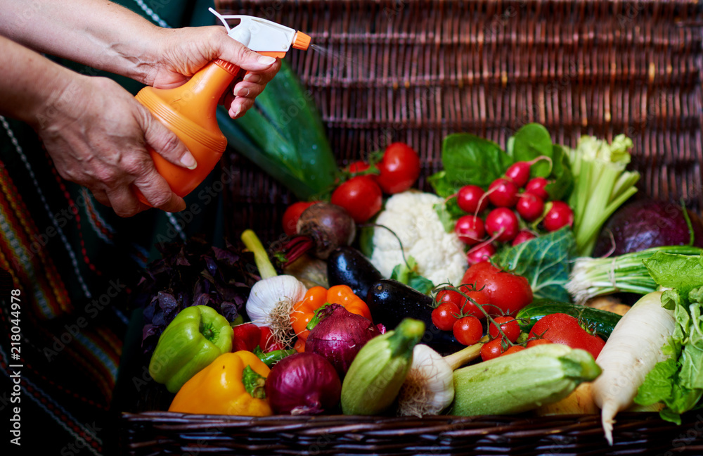 Woomen refreshing vegetable spray them with water, woman sprays the ...