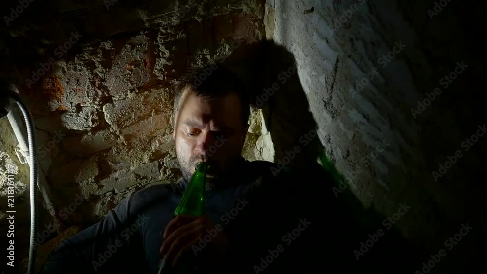 Vídeo do Stock: drunk alcoholic man lying in a ruined building in the ...