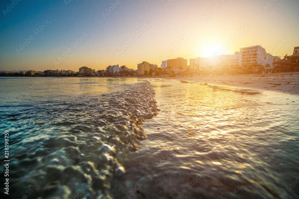 Wavy curves of sea is covered in golden sunset light. Sea at sunset ...