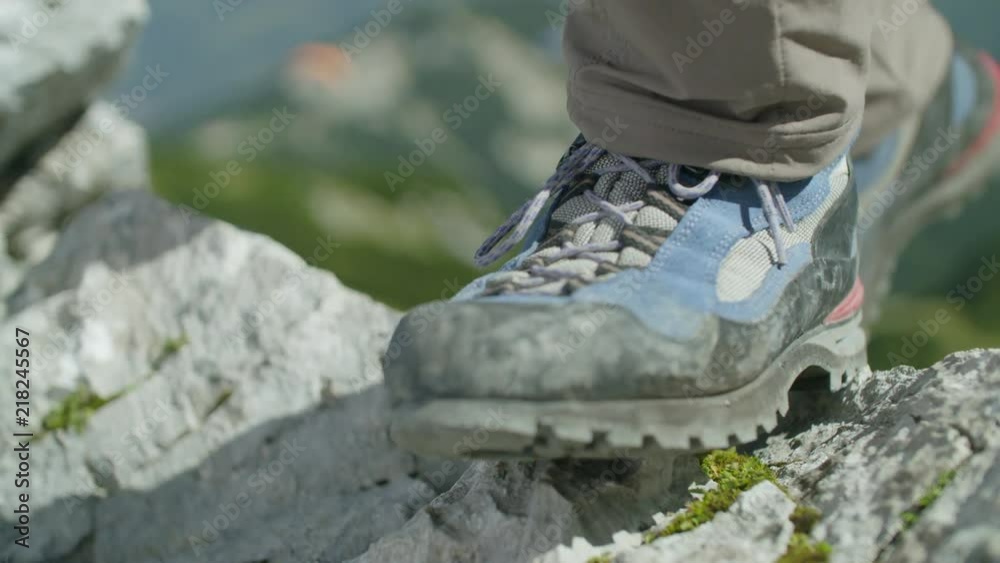 female hiker helps male to climb a steep part of the mountain. Close up ...