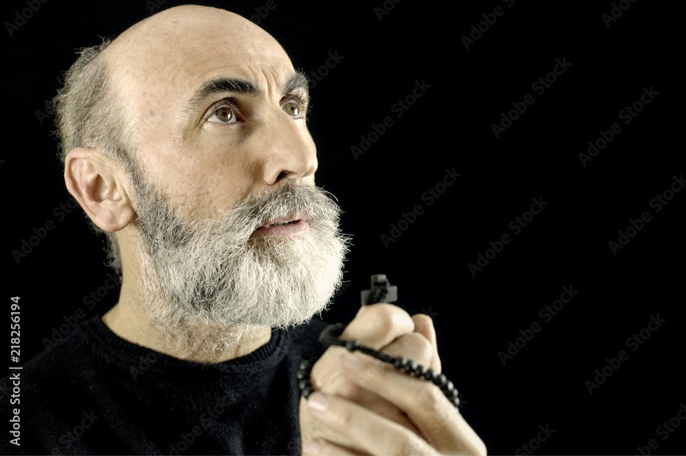 An old man, praying God with a rosary in his wrinkled hands, head and ...