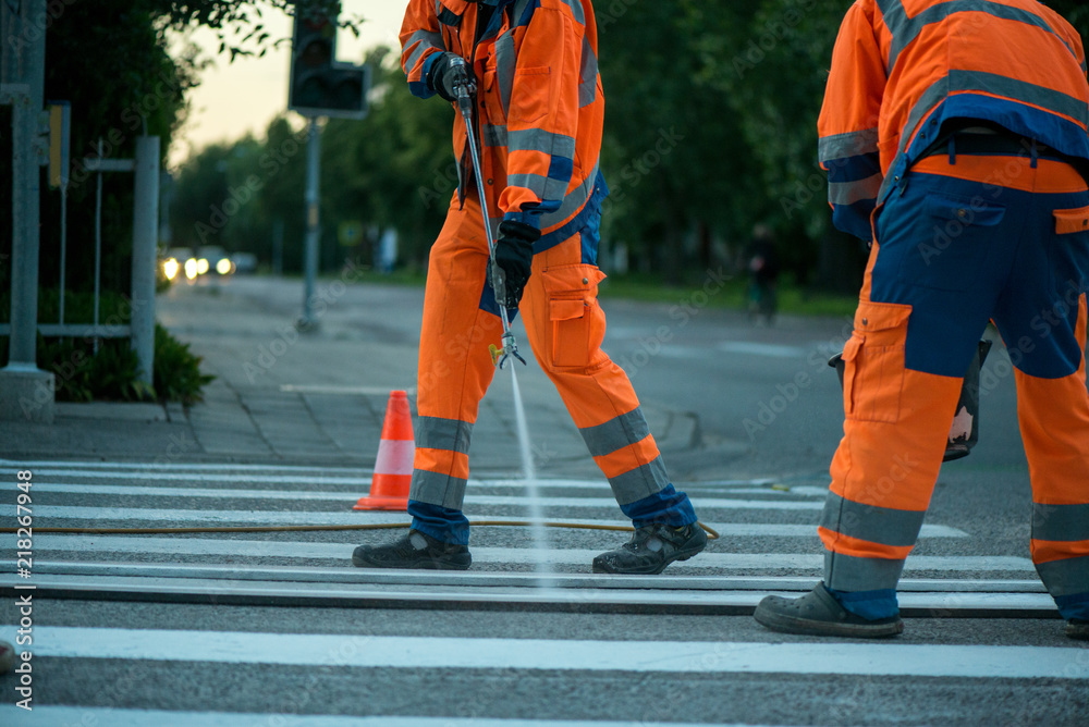Traffic line painting. Workers are painting white street lines on ...