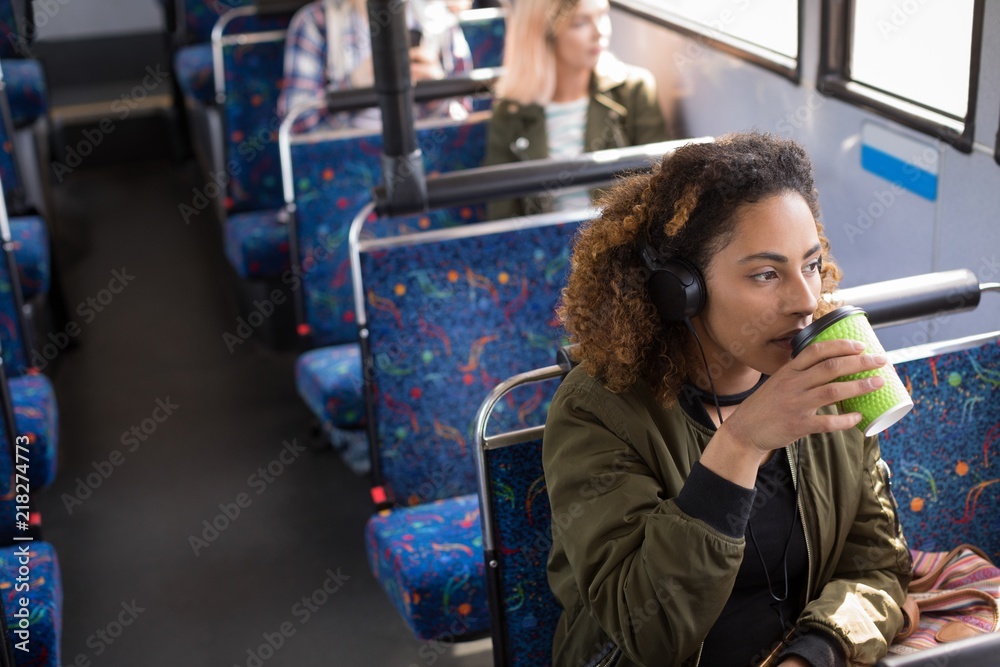 Female commuter having coffee while travelling in modern bus foto de ...