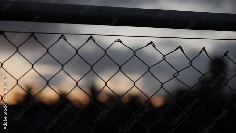 Vidéo Stock Mesh and barbed wire fence rising up slow motion against ...