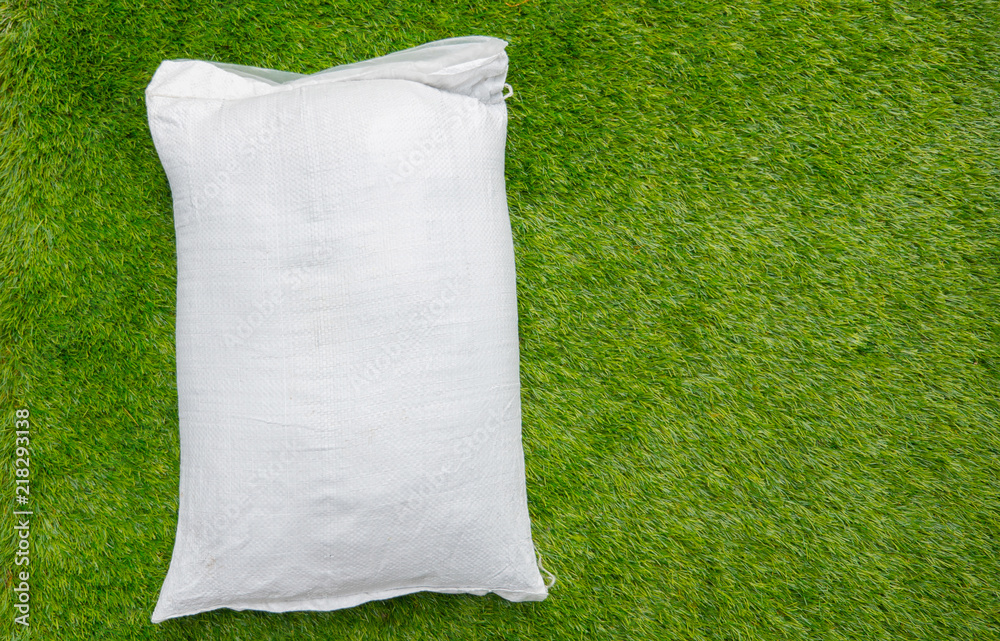 Fertilizer and soil white bag on green grass background Stock Photo ...