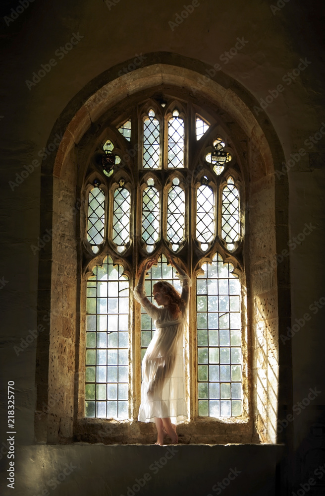 Beautiful model with long red hair posing in a Gothic window Stock ...