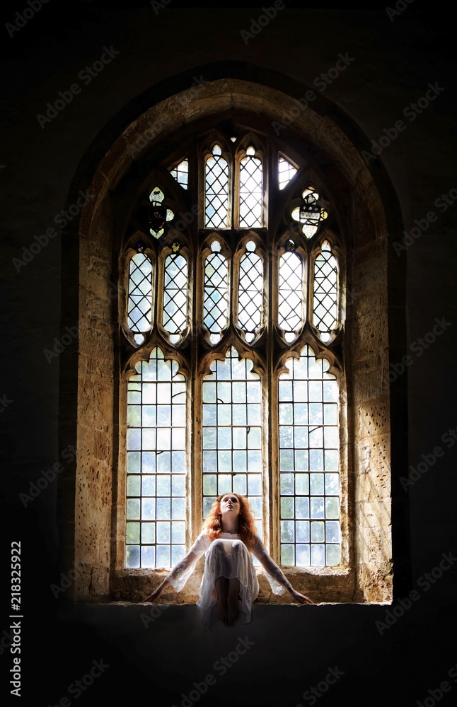 Beautiful model with long red hair posing in a Gothic window Stock ...