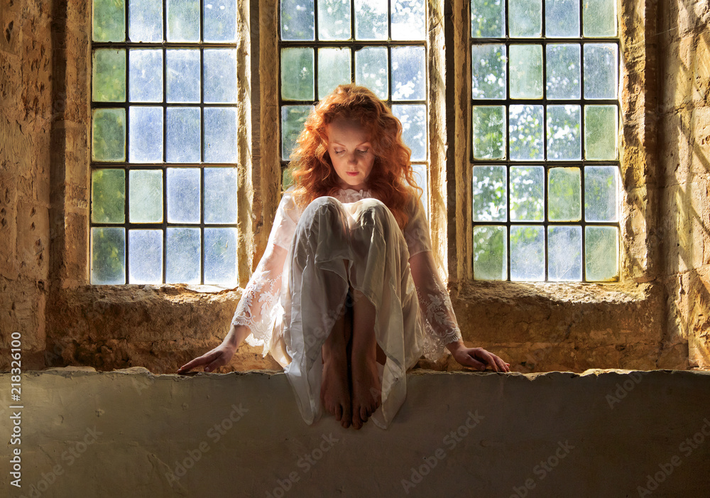 Beautiful model with long red hair posing in a Gothic window Stock ...