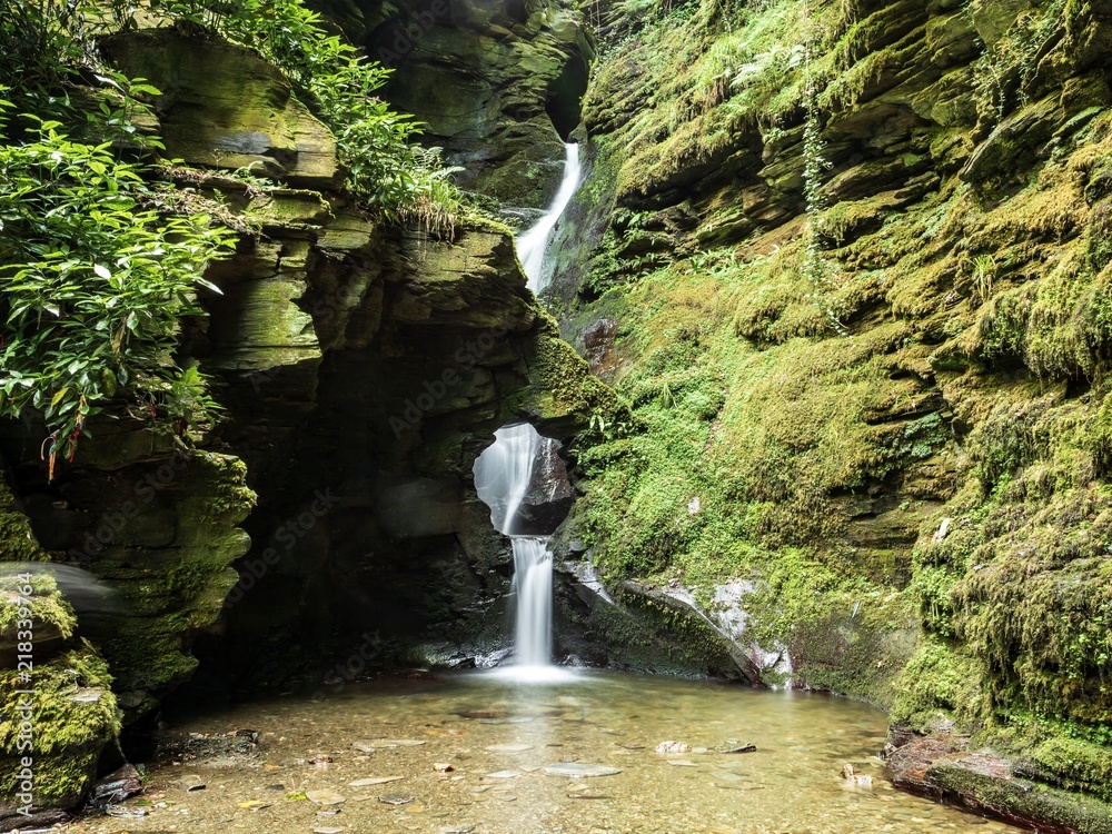 Foto de A waterfall through a hole in the rock at St Nectan's Glen in ...
