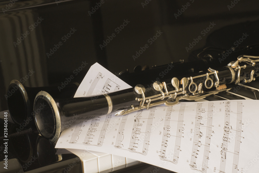 clarinet and music sheet over grand piano keys reflecting on piano ...