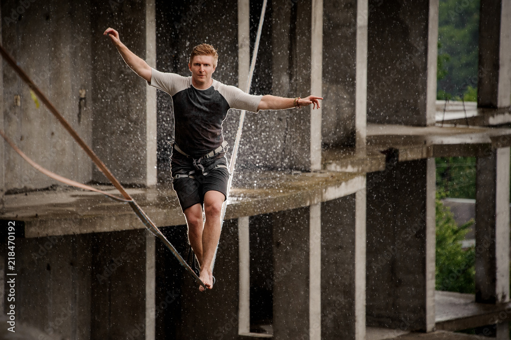 Strong and brave young man balancing on a slackline Stock Photo | Adobe ...
