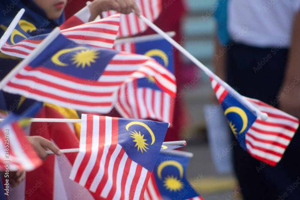 Hand waving Malaysia flag also known as Jalur Gemilang in conjunction ...