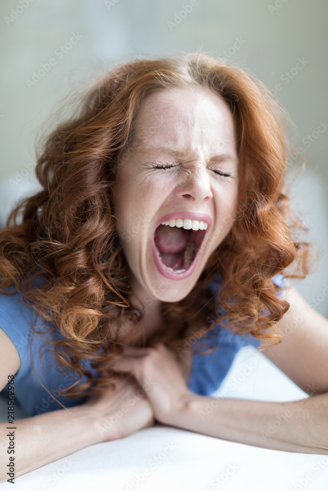 Young red-haired woman yawning Stock Photo | Adobe Stock