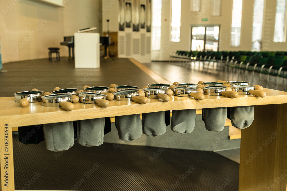 Rack with grey velvet offering or collecting bags in a church with ...