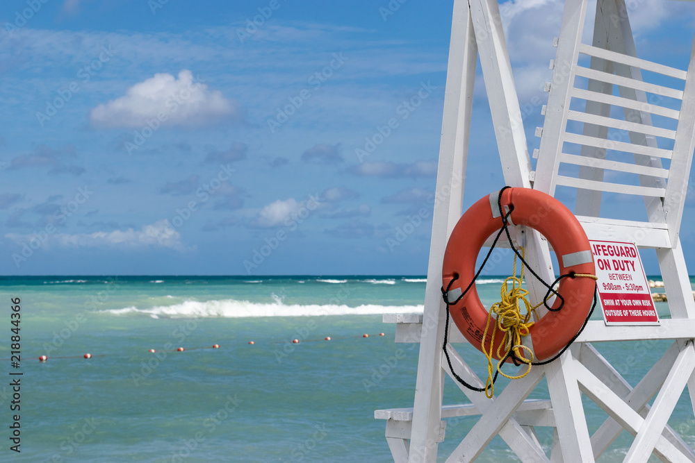 Empty LifeGuard Chair with On Duty Hours sign and orange buoy, by the ...