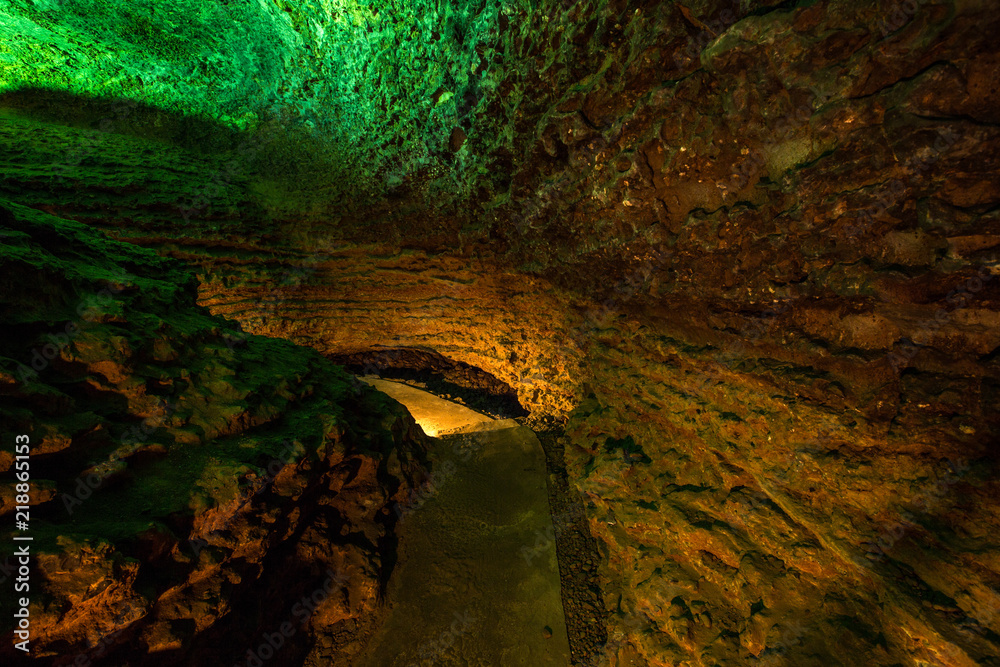 Abstract cave interior chamber photograph - colored lights, bumpy rock ...