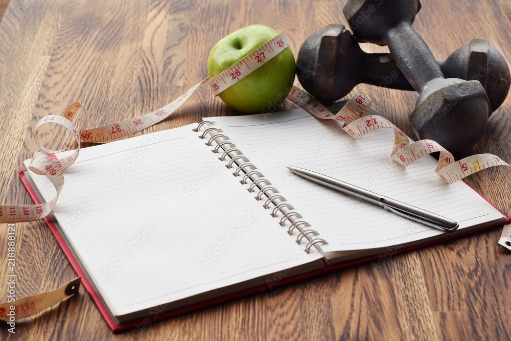Diet plan concept, Green apple, measuring tape and 2 dumbbell with ...