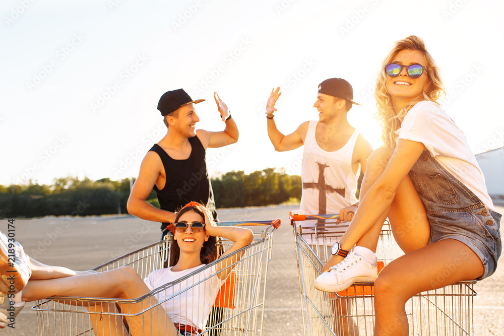 Friends ride on carts, Friends high-five each other, near the ...