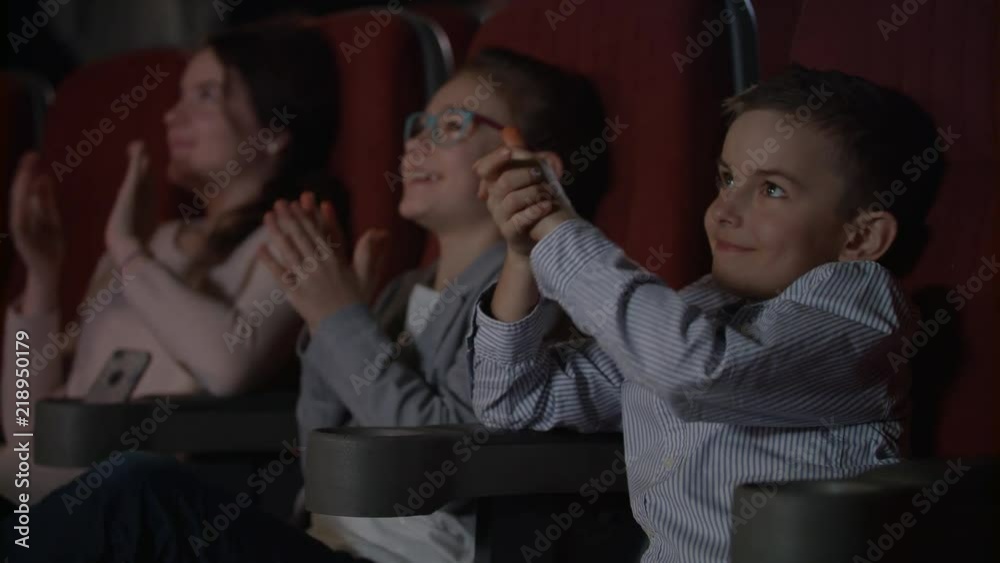 Satisfied children applauding in cinema. Storm of applause in cinema ...