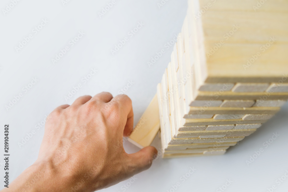 The tower from wooden blocks and man's hand take one block. Stock Photo ...